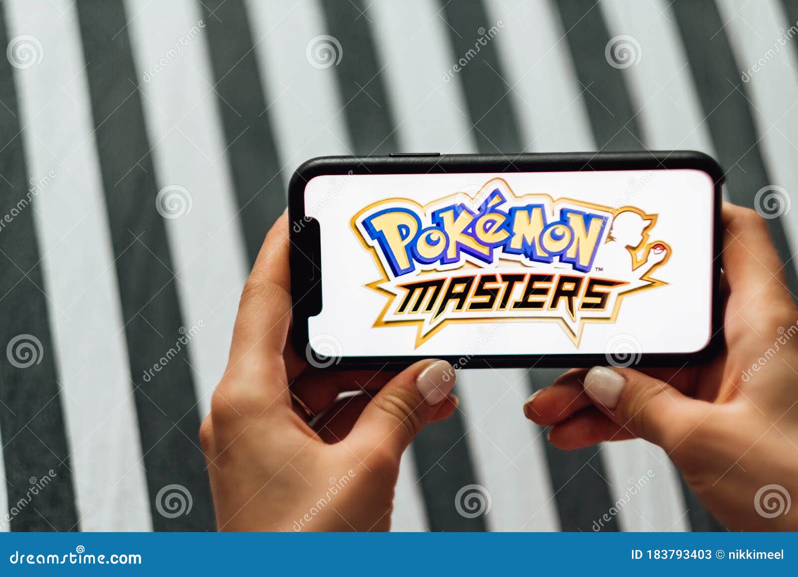 Hands Holding IPhone with Pokemon Masters on the Screen. Editorial ...