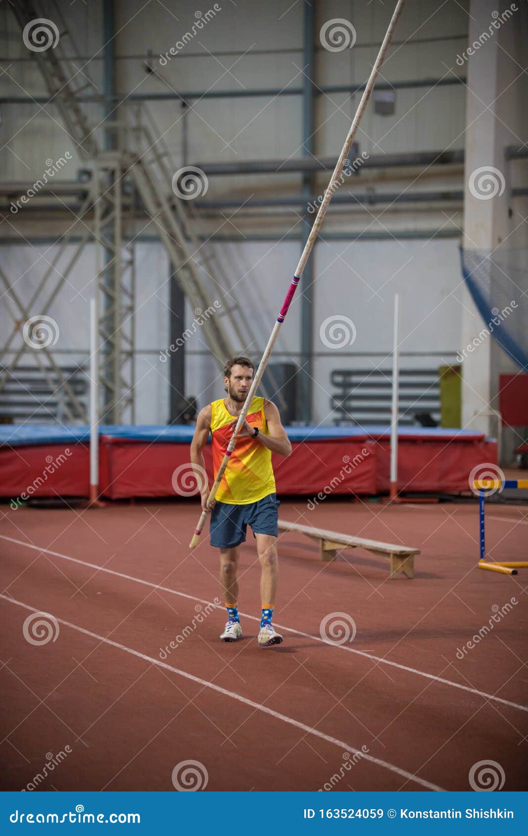 Pole Vaulting Indoors - a Man Standing on the Track with a Pole Stock ...