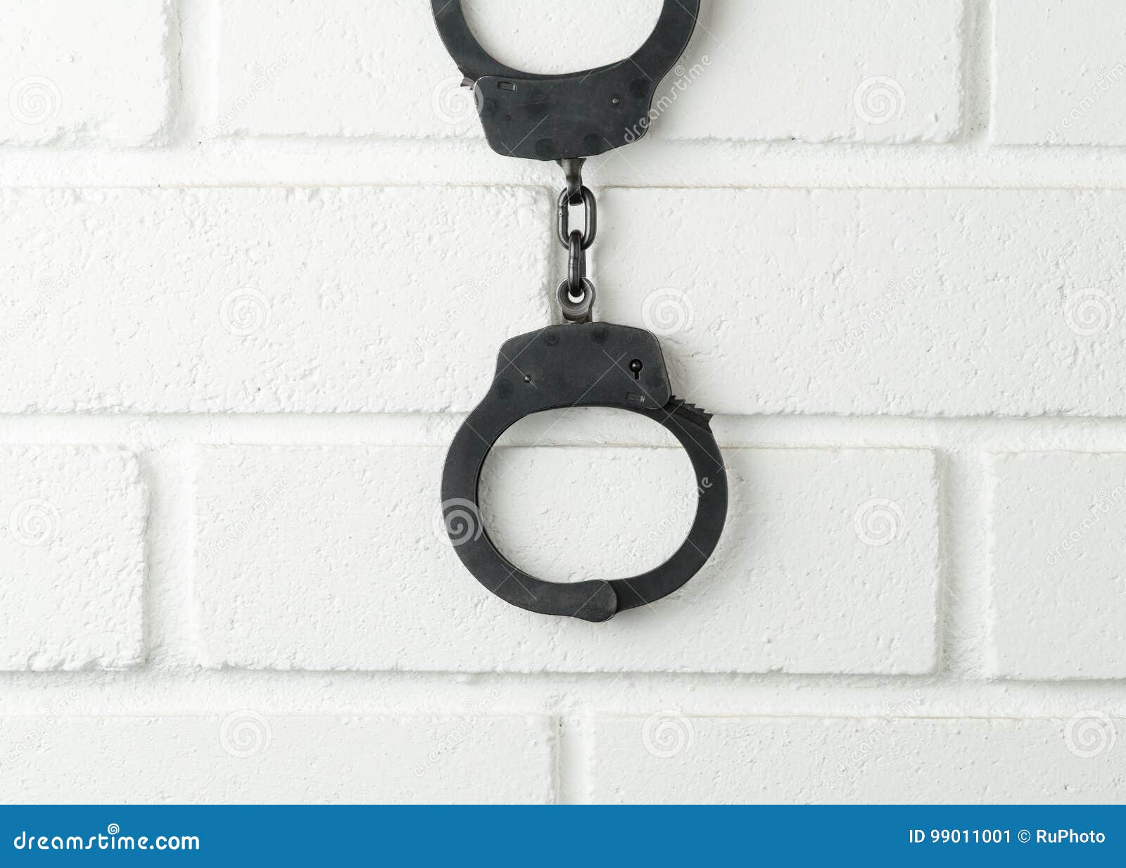 Police Handcuffs on a White Painted Brick Wall Stock Image - Image of ...