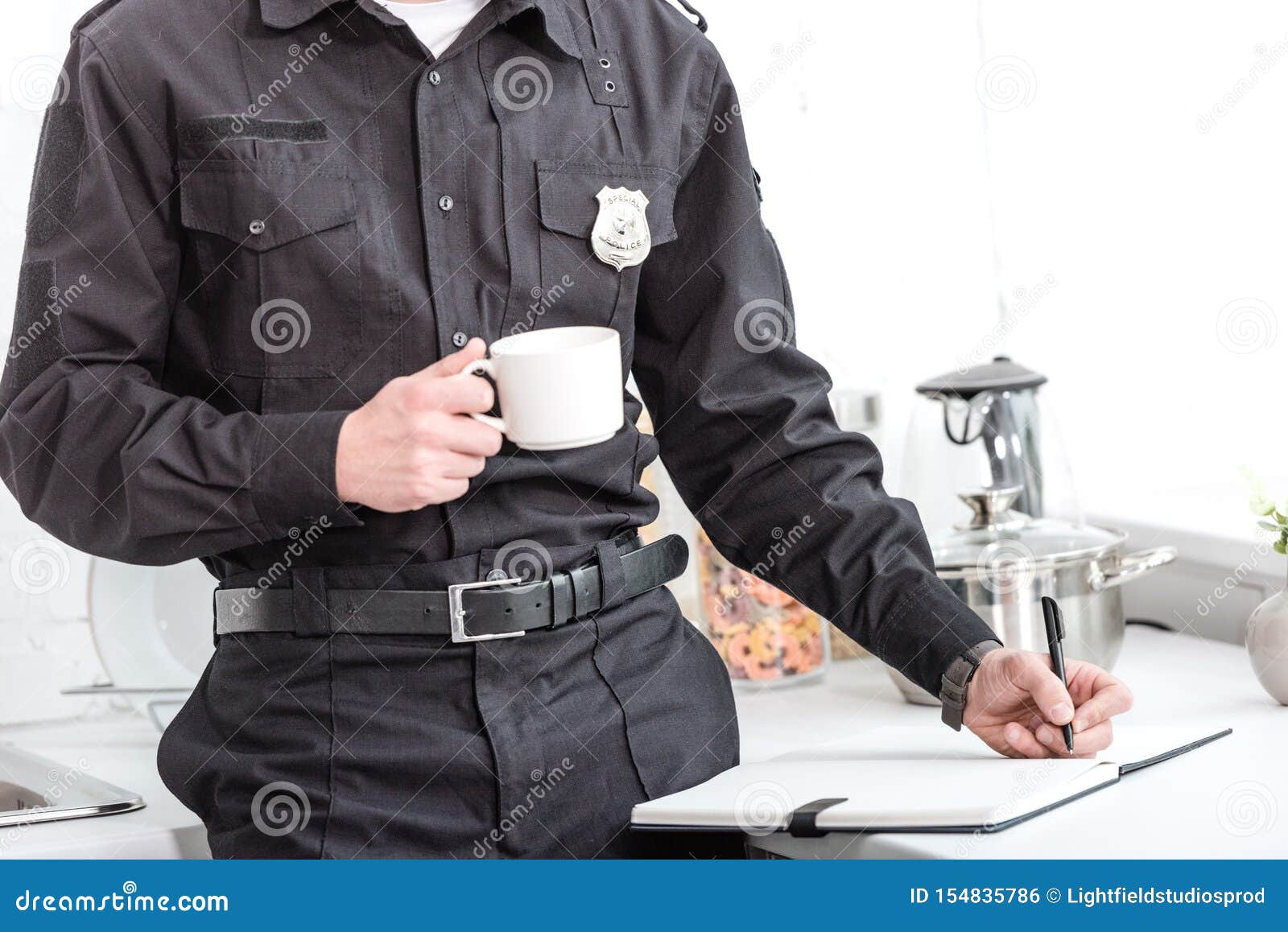 Police Officer Drinking Coffee and Writing in Notebook Stock Photo ...