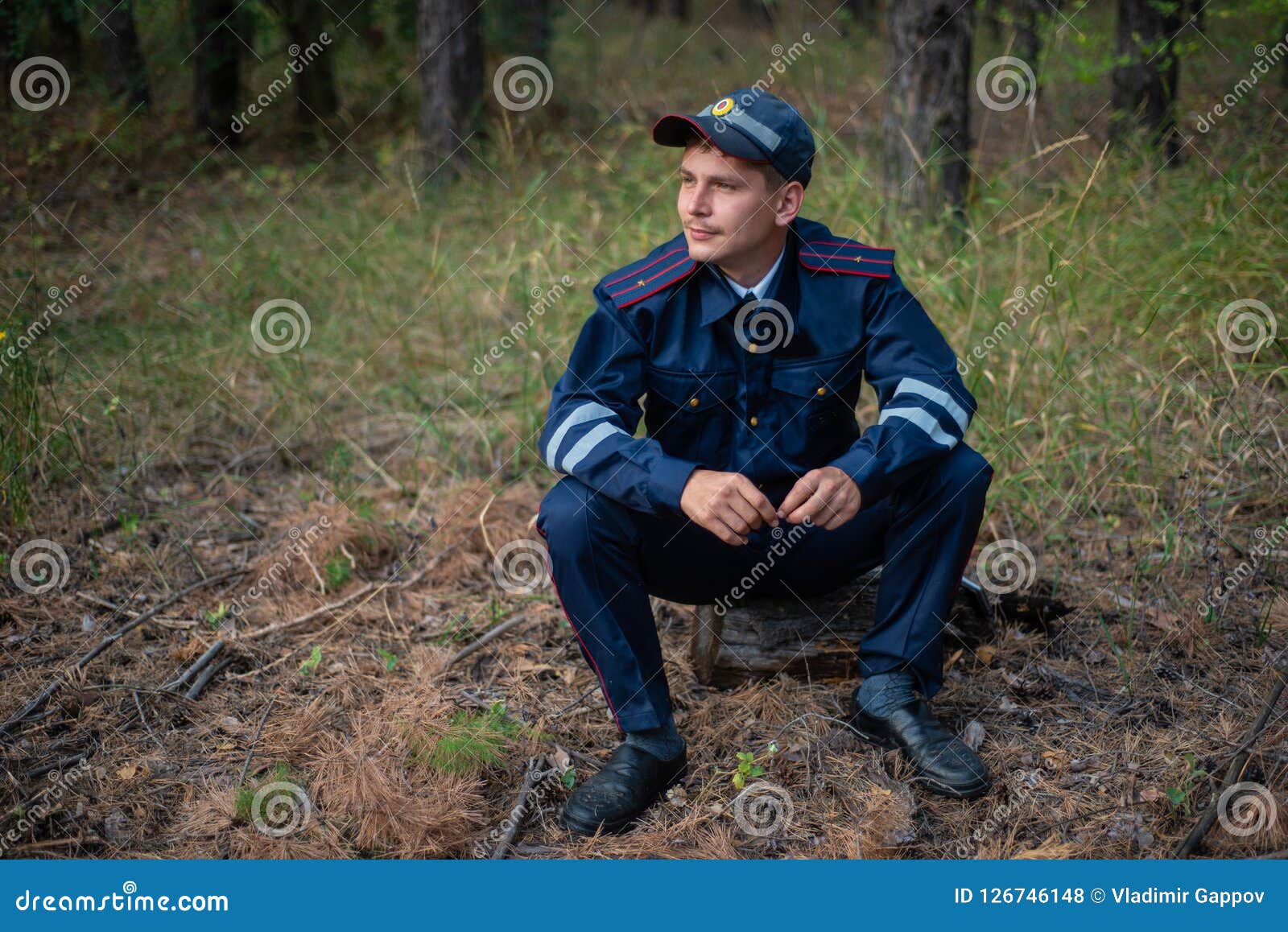 Policeman Sits on the Grass in the Forest and Thinks Stock Photo ...