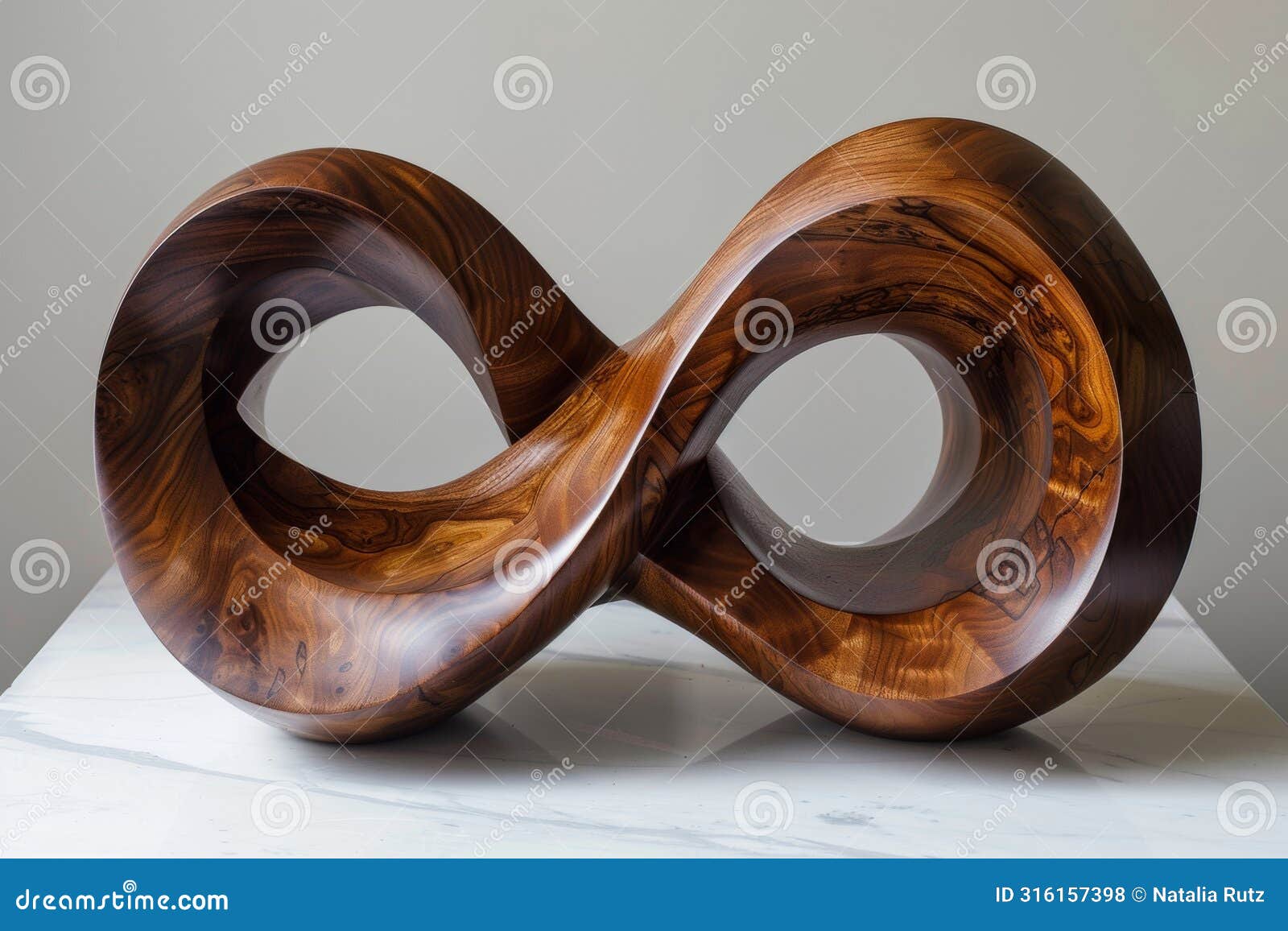 Polished Walnut Wood Infinity Loop Sculpture on a White Surface Stock ...