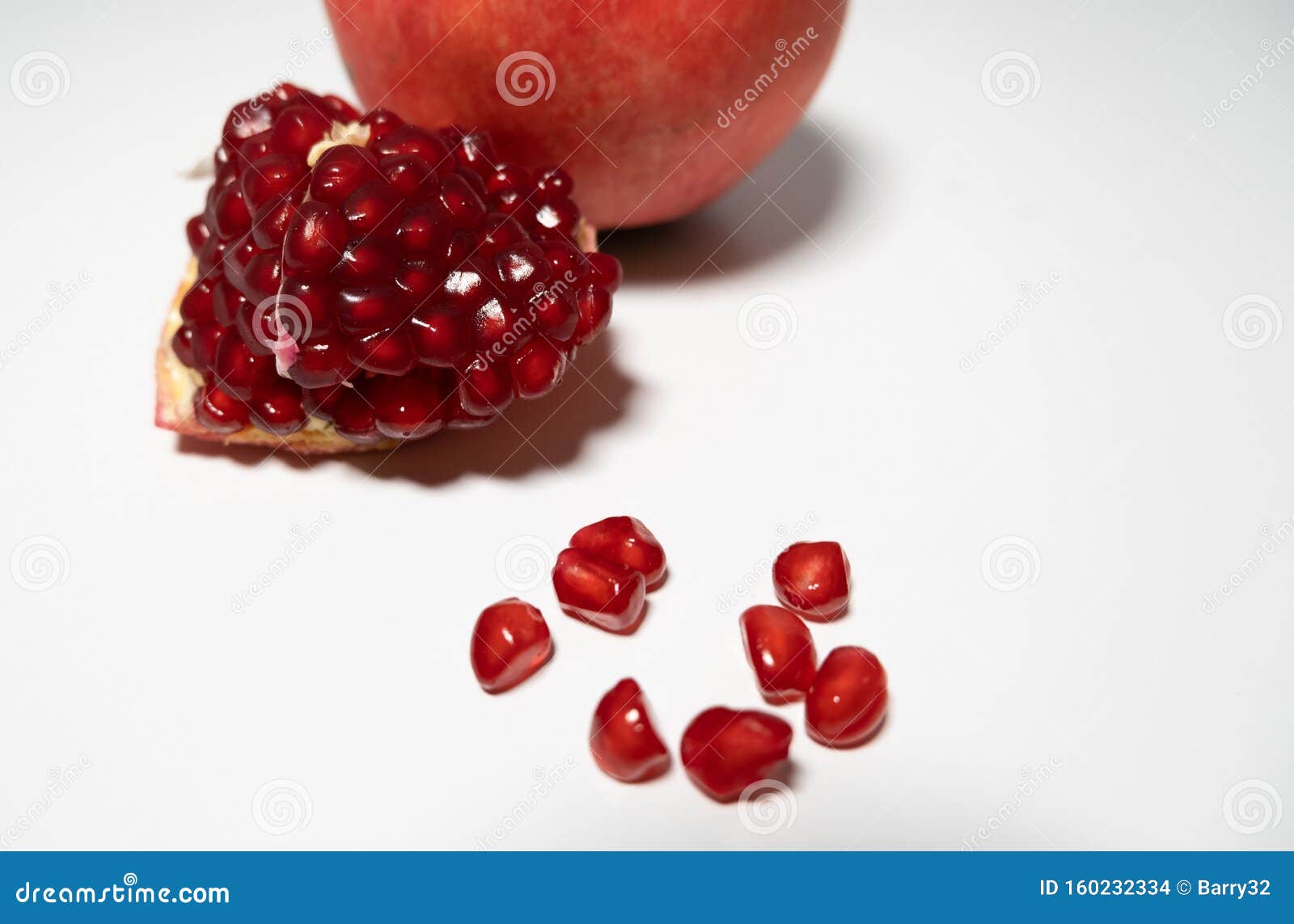 Pomegranate Fruit, Split Open with Seeds Spilling Onto White Table ...