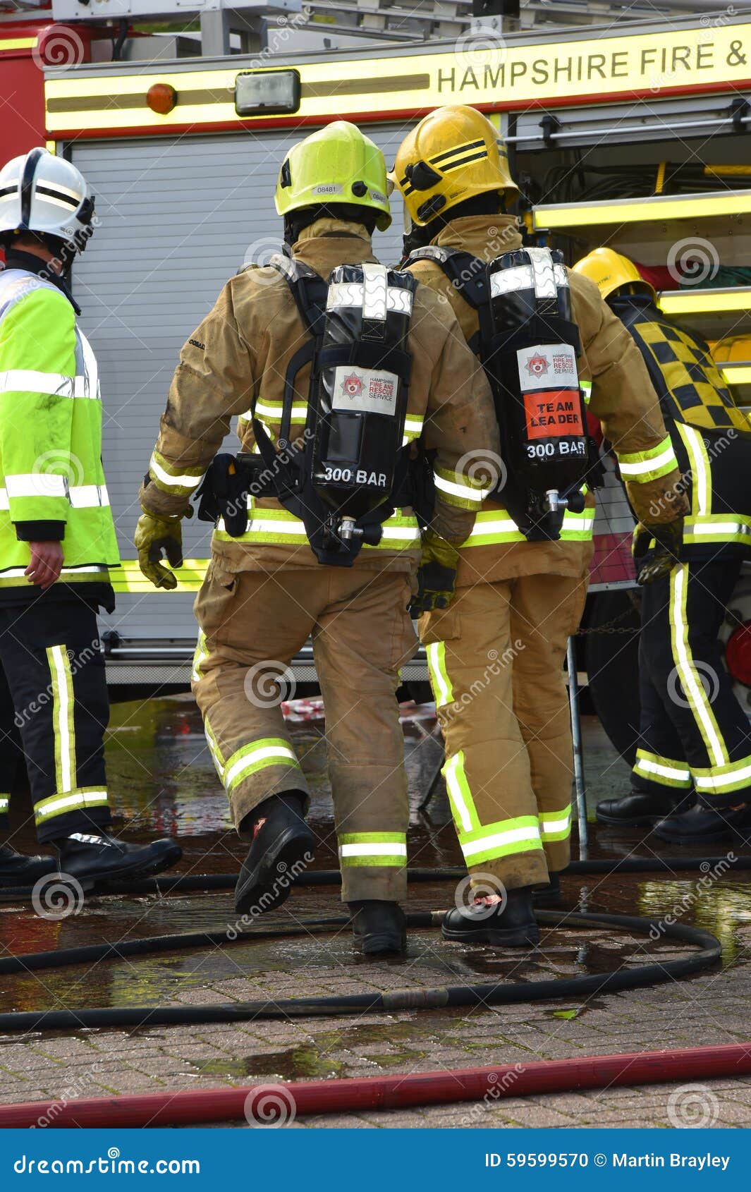 Pompieri in Respiratore Con L'autopompa Antincendio Immagine Editoriale ...