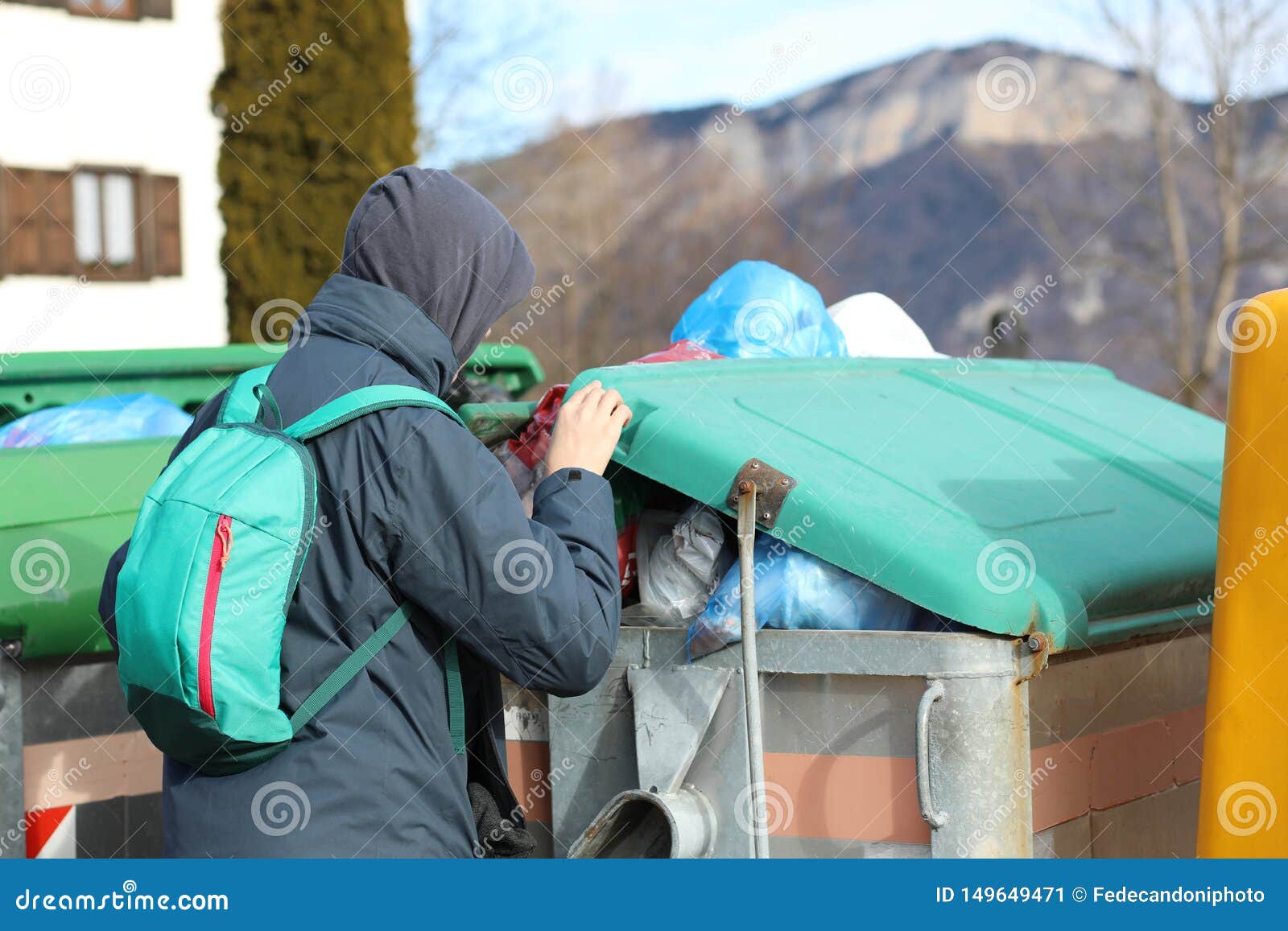 Poor Boy with a Backpack on His Back Searching in the Rubbish Bi Stock ...