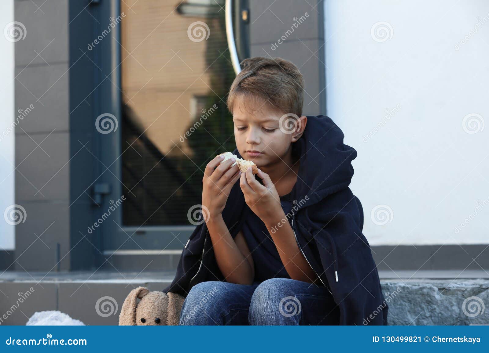 Poor little boy with bread stock image. Image of beggar - 130499821