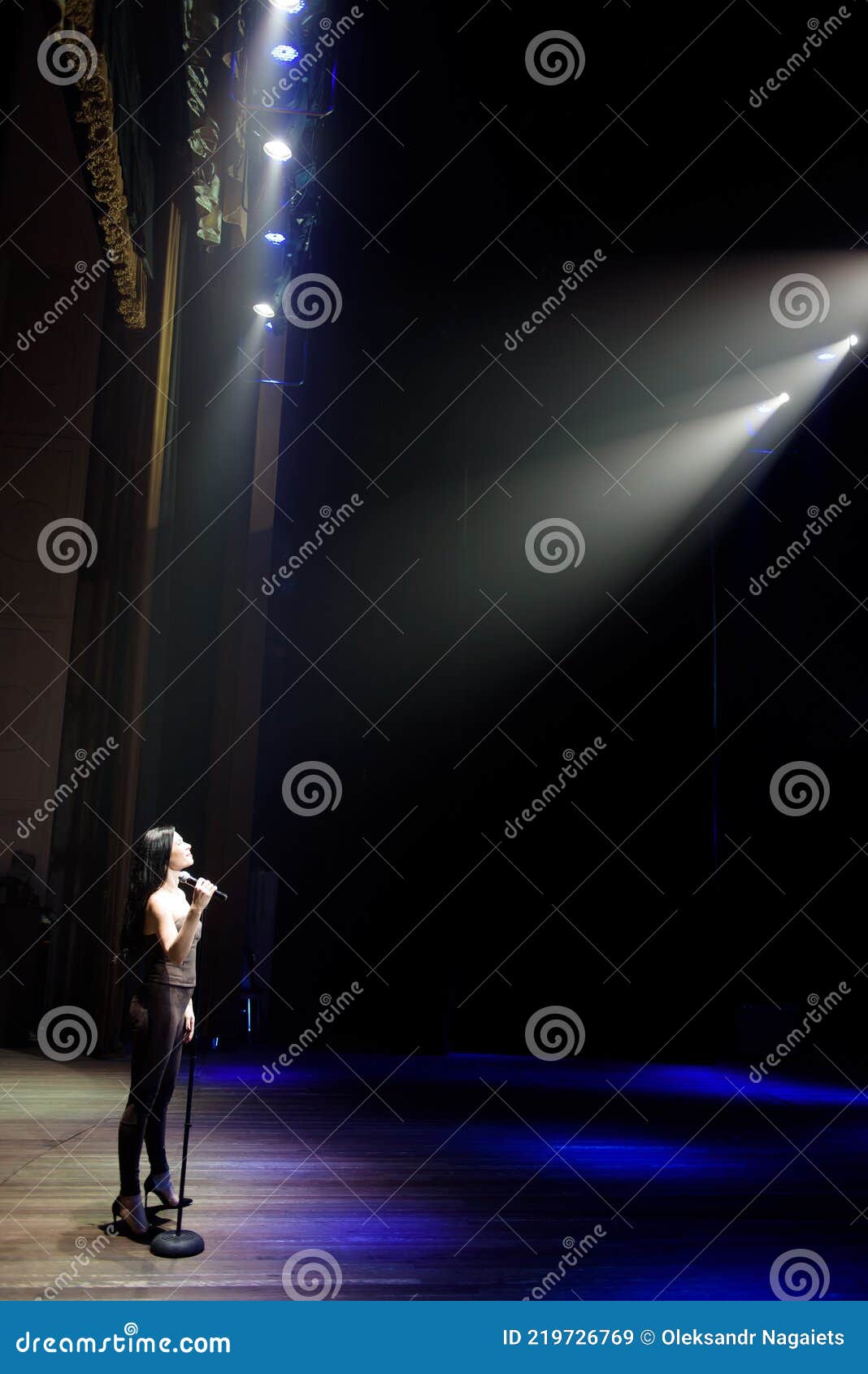 Pop Musician with Microphone Singing a Song on the Stage in Blue Light ...