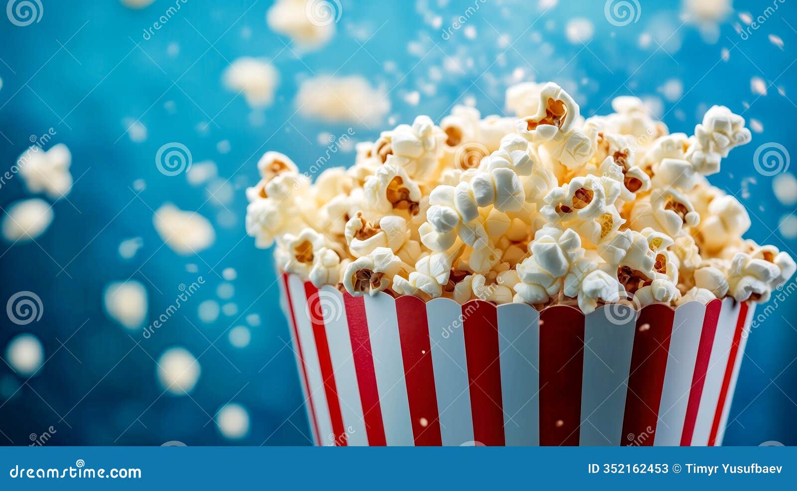 Popcorn Exploding from Classic Red and White Striped Container on Blue ...