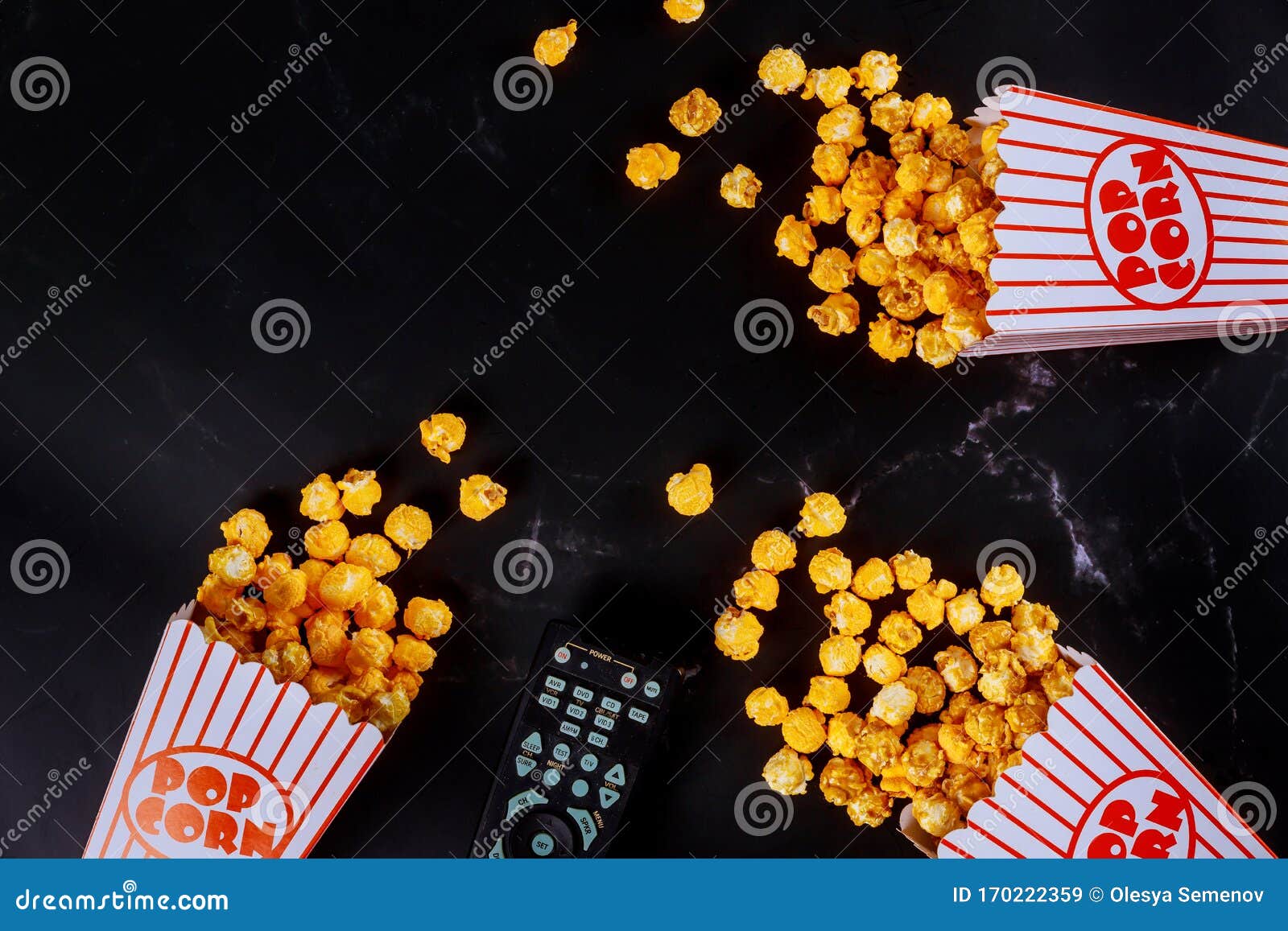 Popcorn in Striped Boxes Spilled on Black Background with Remote ...