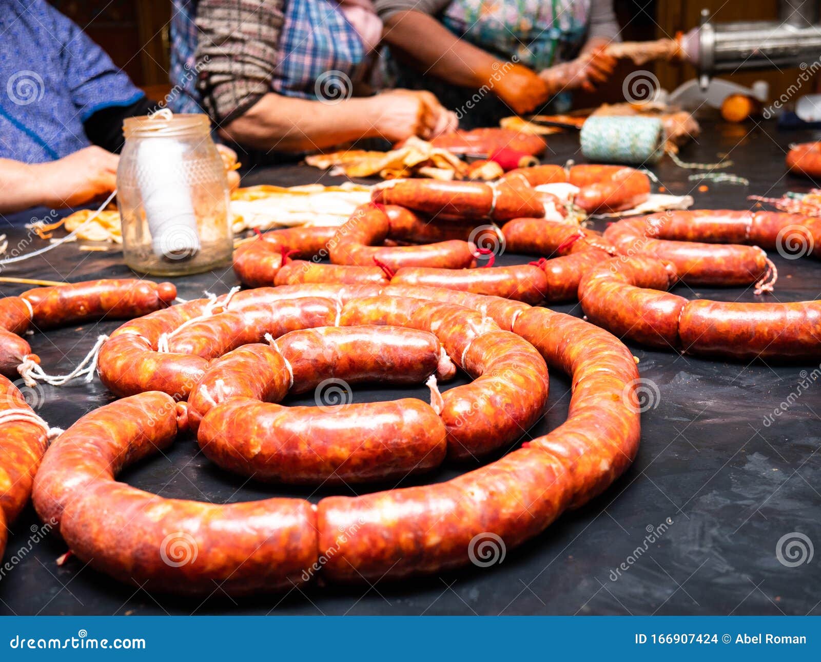 Pork Strings on a Black Table while Working Women Stuff the Pork Guts ...