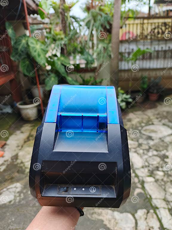 Portable Bluetooth Printer on Hand, Blue Color with Blur Background ...