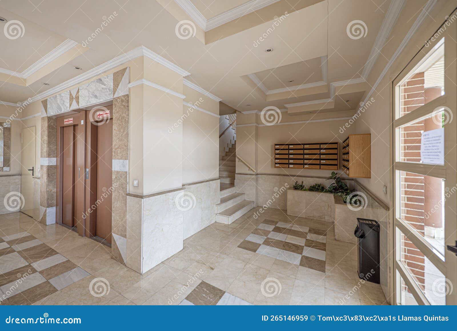 Portal of a Building with Light Colored Marble Tiles and Twin Elevators ...