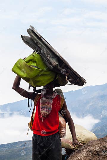 Porter carrying heavy load editorial stock photo. Image of excessive ...