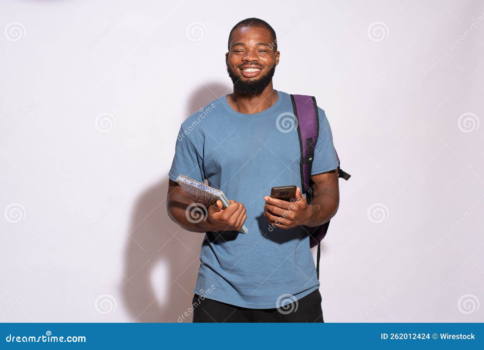 Smiling African Male Student Standing Against a White Wall Stock Photo ...