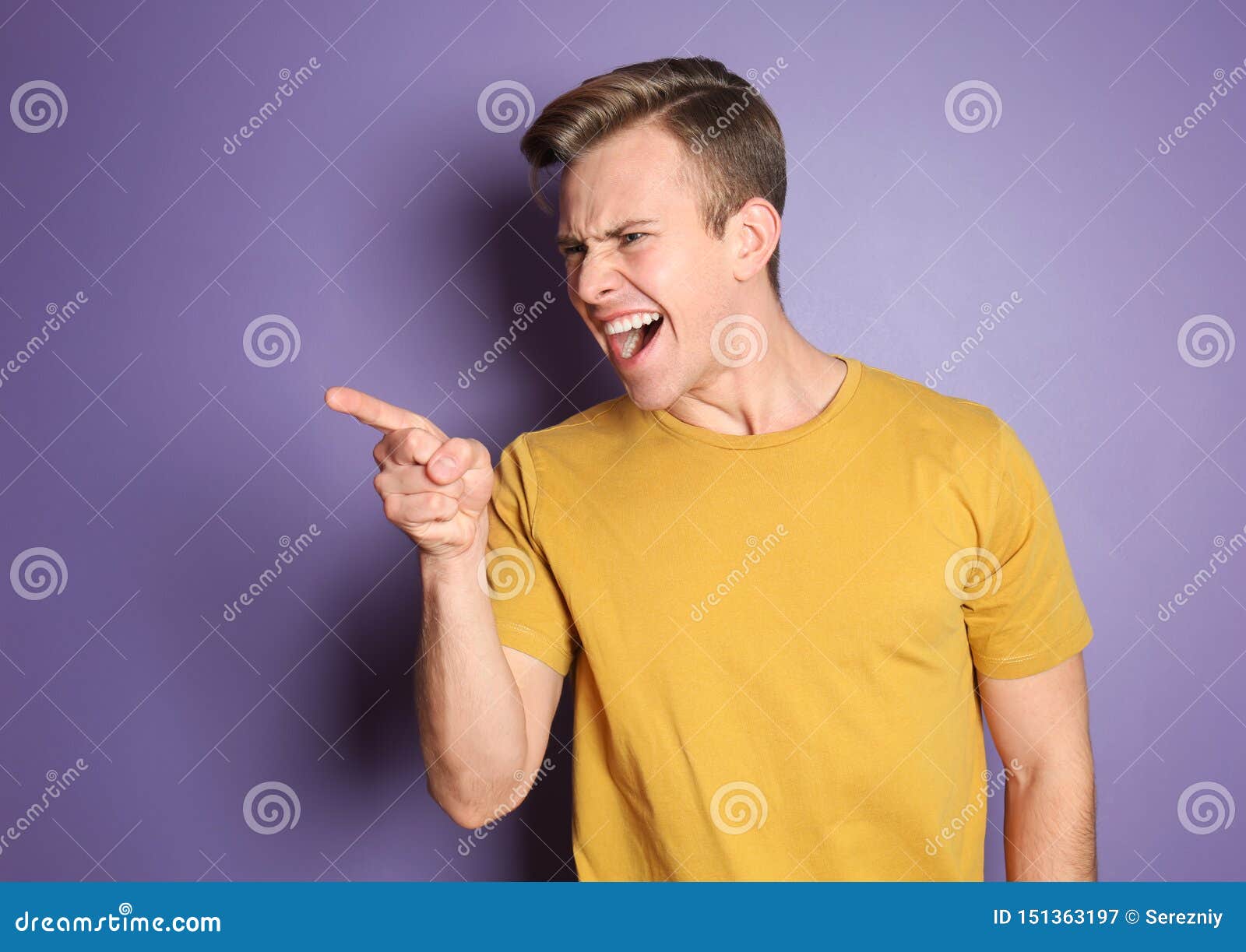 Portrait Of Aggressive Young Man On Color Background Stock Photo ...