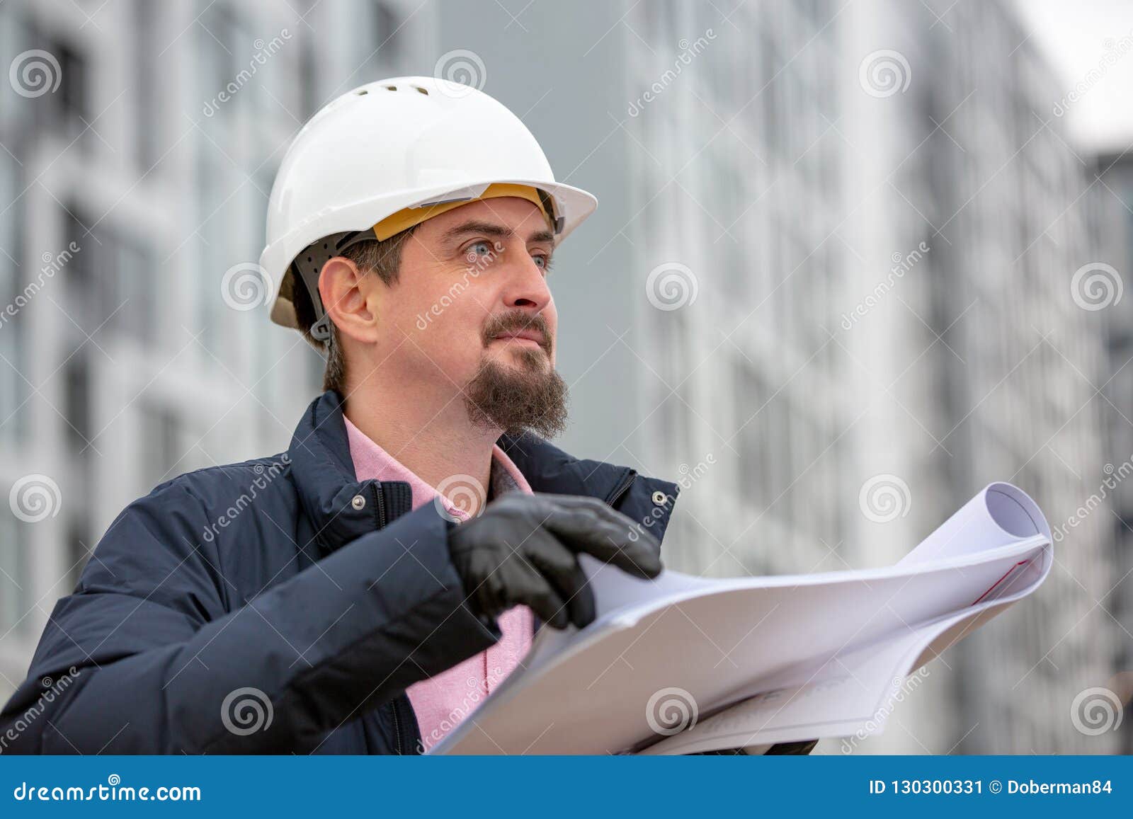 Portrait of Architect at Work with Helmet in a Construction Site, Reads ...