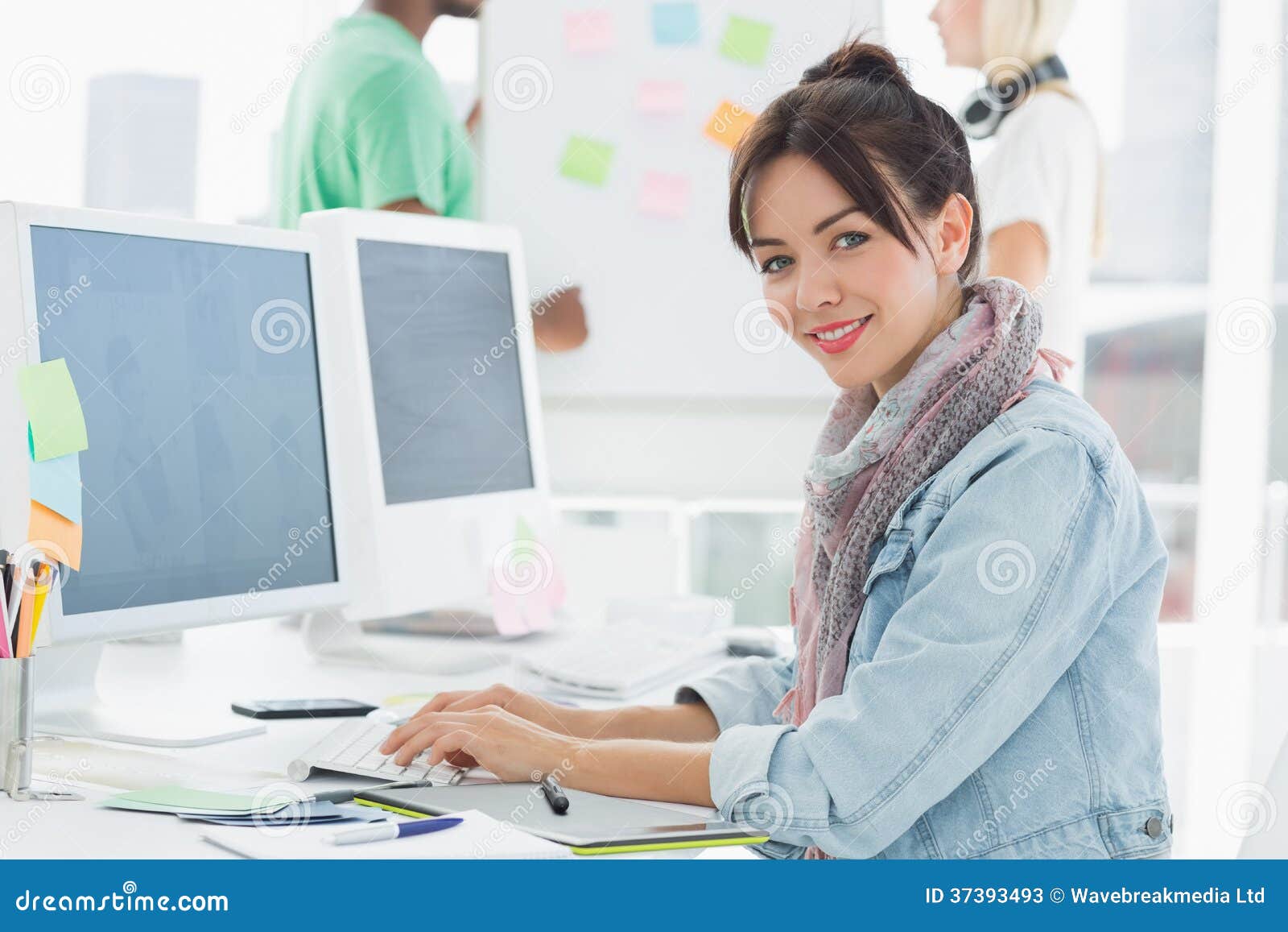 Portrait of an Artist Using Computer with Colleagues Behind Stock Image ...