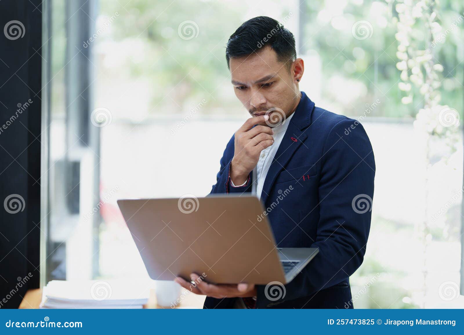 Portrait of an Asian Male Business Owner Standing Using a Computer To ...