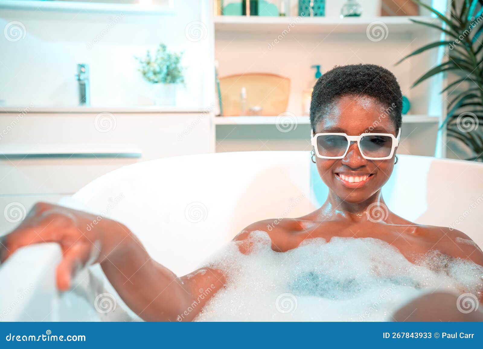 Portrait Of An Attractive African Woman In Foam Bathtub With Sunglasses