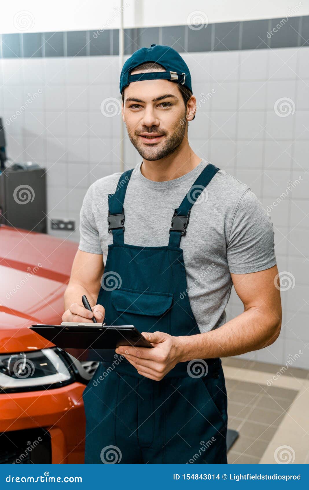 Portrait Of Auto Mechanic With Notepad Examining Car Royalty-Free Stock ...