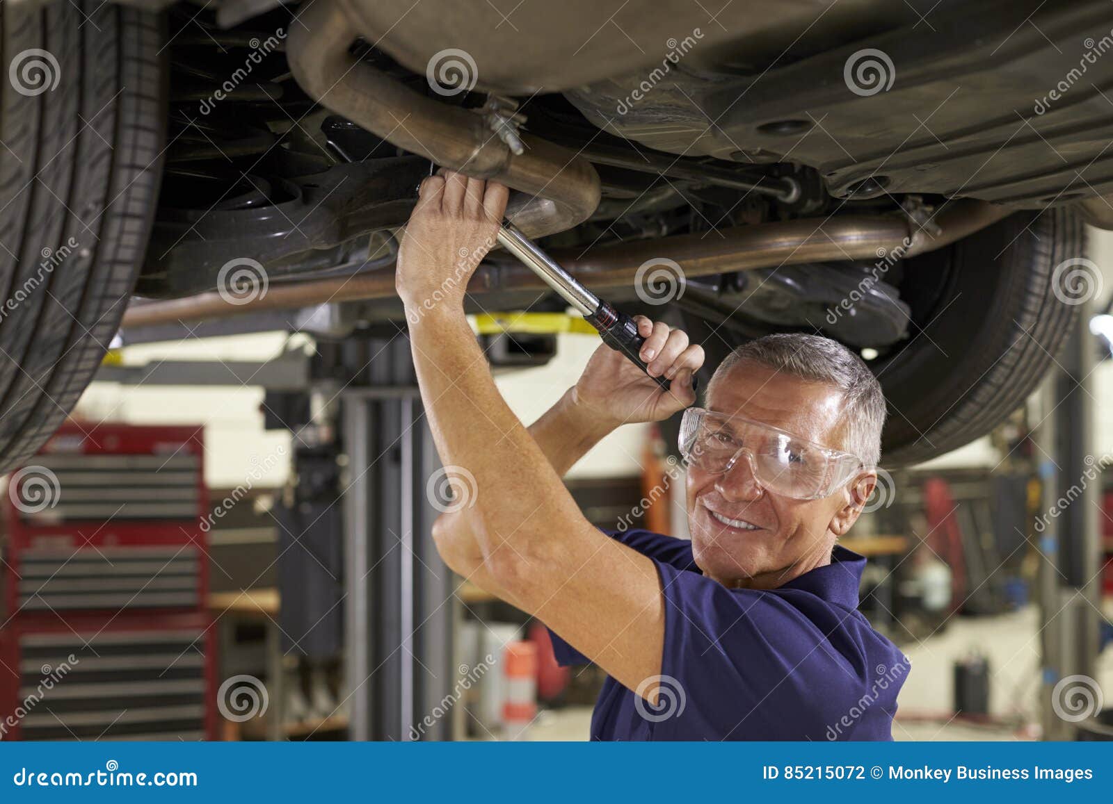 Portrait of Auto Mechanic Working Underneath Car in Garage Stock Photo ...