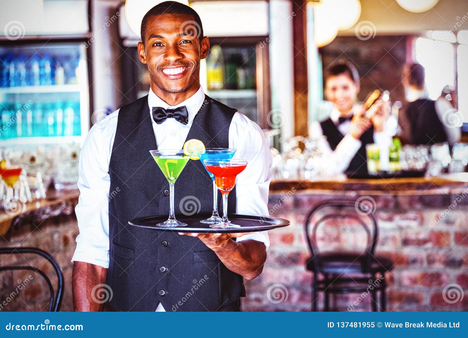 Portrait Of Bartender Holding Serving Tray With Cocktail Glasses Stock