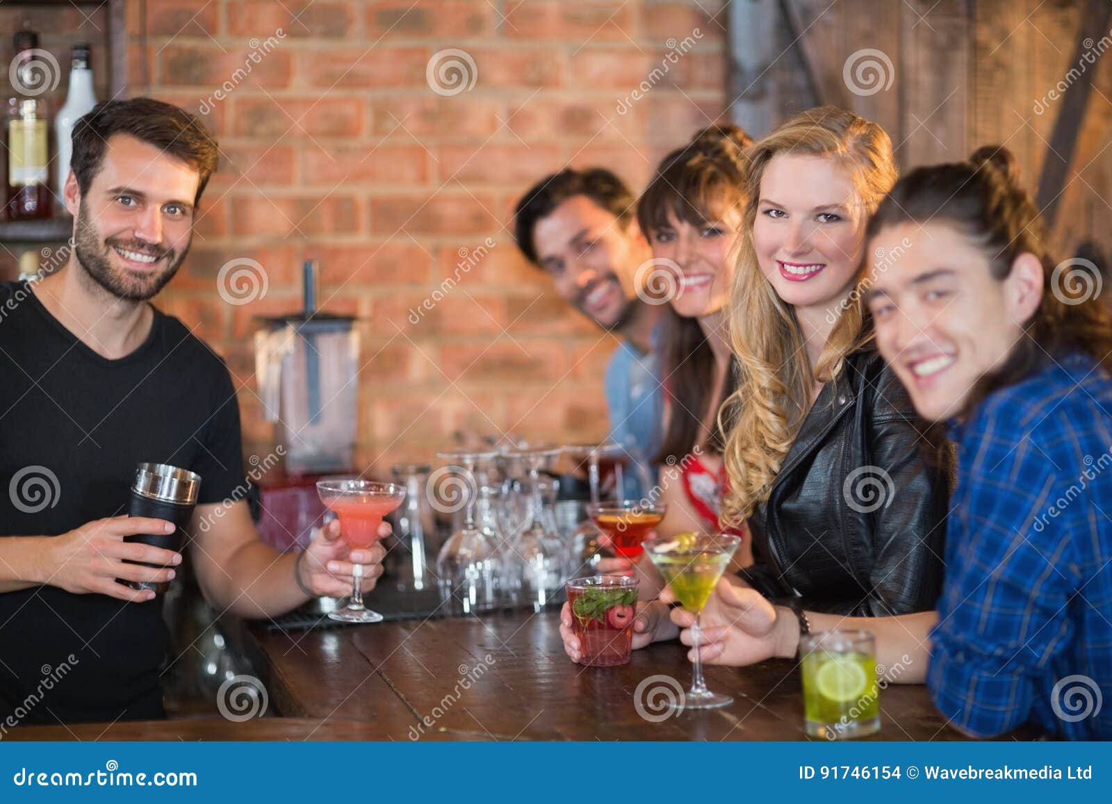 Portrait of Bartender Serving Drinks To Happy Customers Stock Photo ...