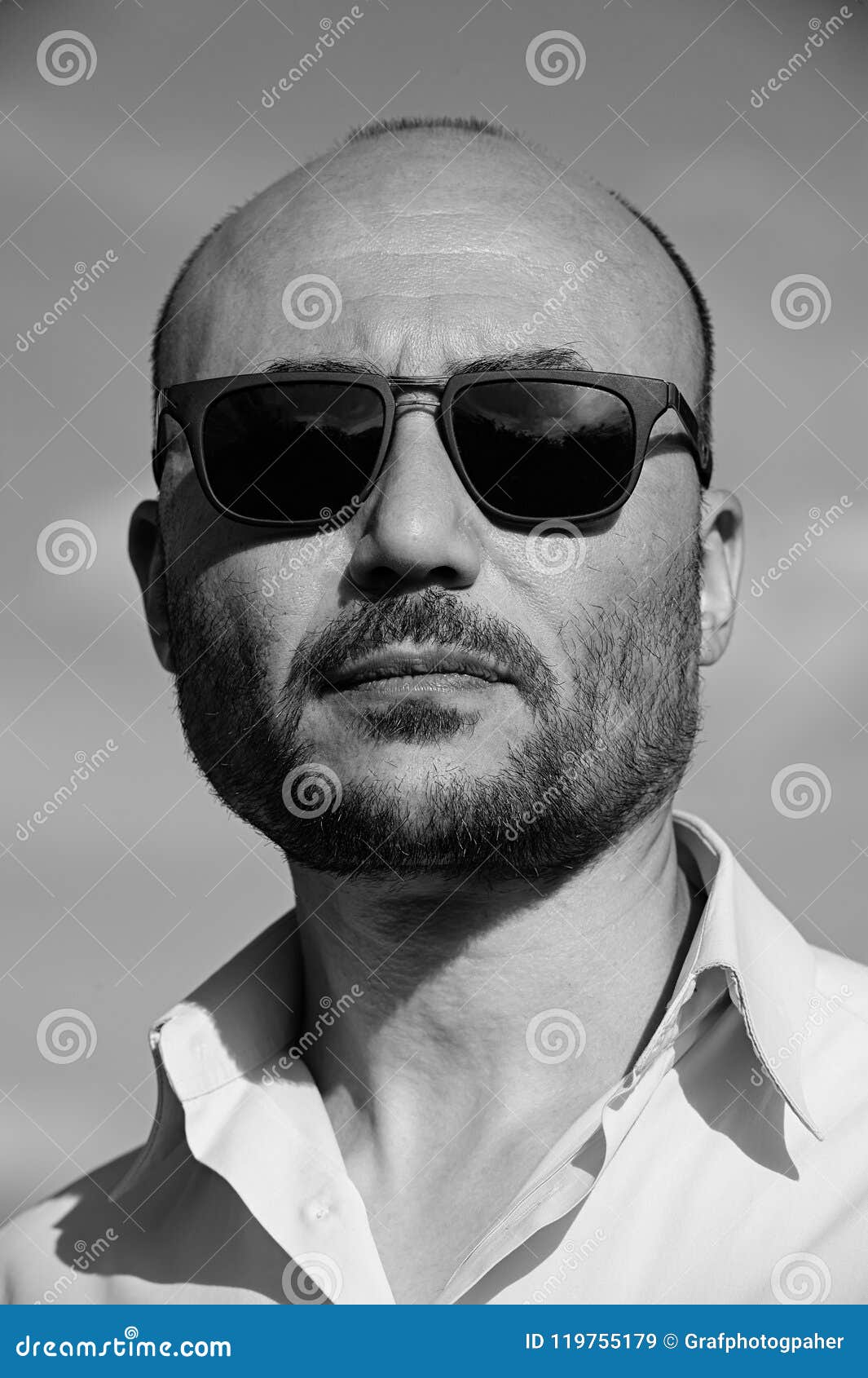 Portrait Of A Bearded Man Wearing Sunglasses Against The Sky Stock