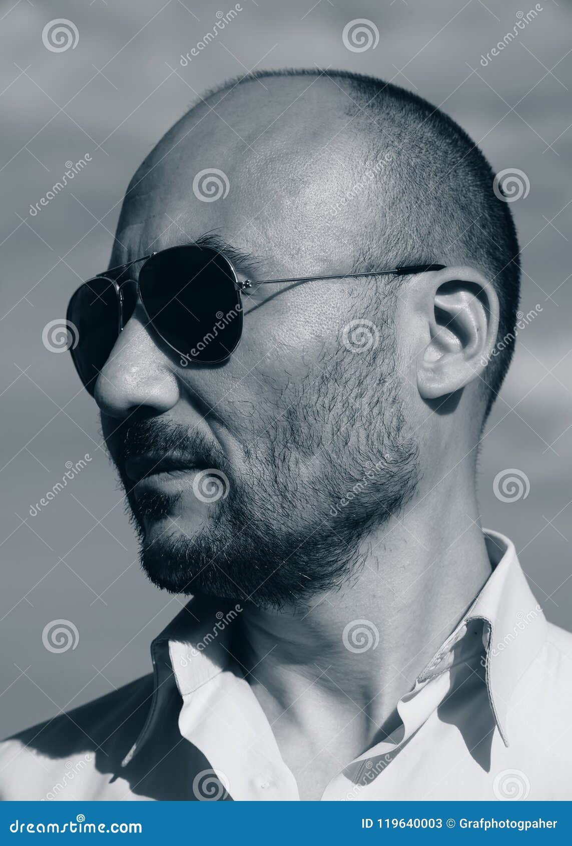 Portrait Of A Bearded Mature Man Wearing Sunglasses Against The Stock