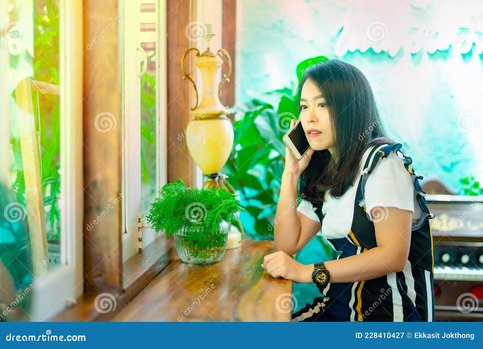Portrait Of A Beautiful Asian Woman Using Her Mobile Phone In A Coffee