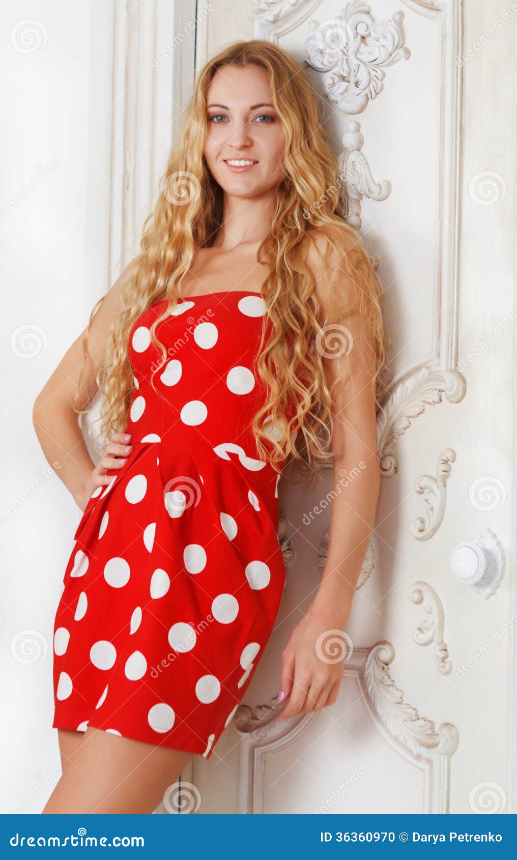 Portrait Of The Beautiful Blond Girl In Polka Dots Dress In Living Room