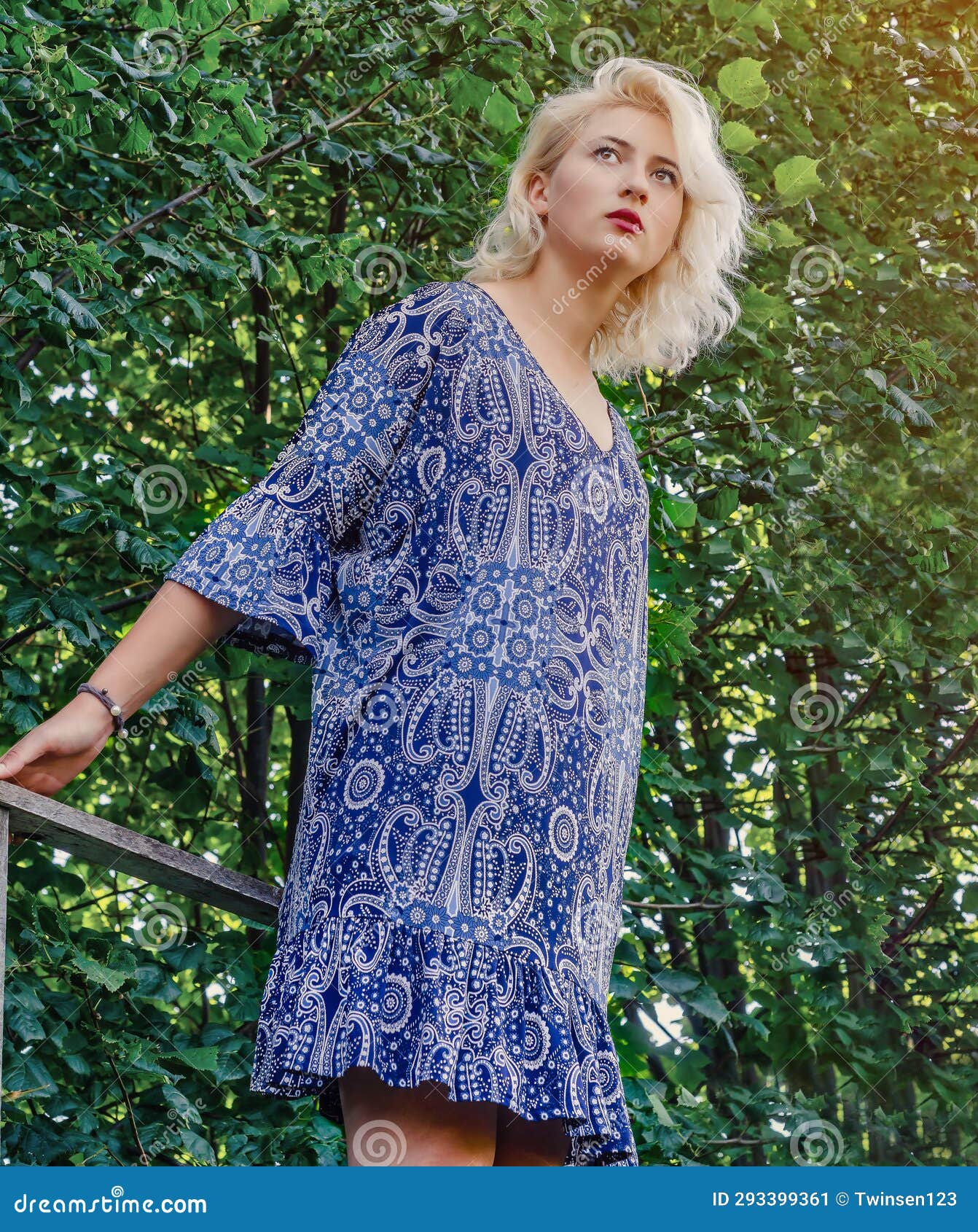 Portrait Of Beautiful Blonde Woman On Background Of Green Trees Woman