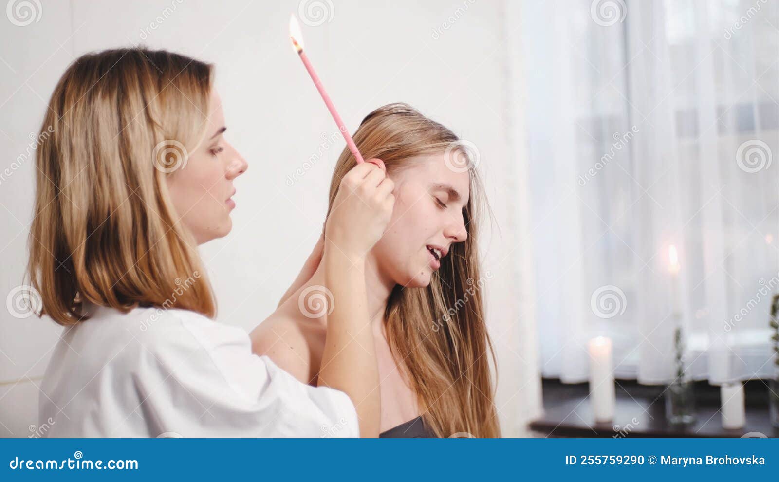 Portrait Of Beautiful Blonde Woman Receiving Ear Candle Treatment At