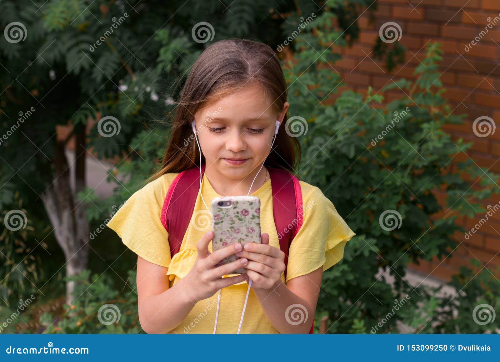 Beautiful Little Girl with a Backpack Using a Mobile Phone Stock Photo ...