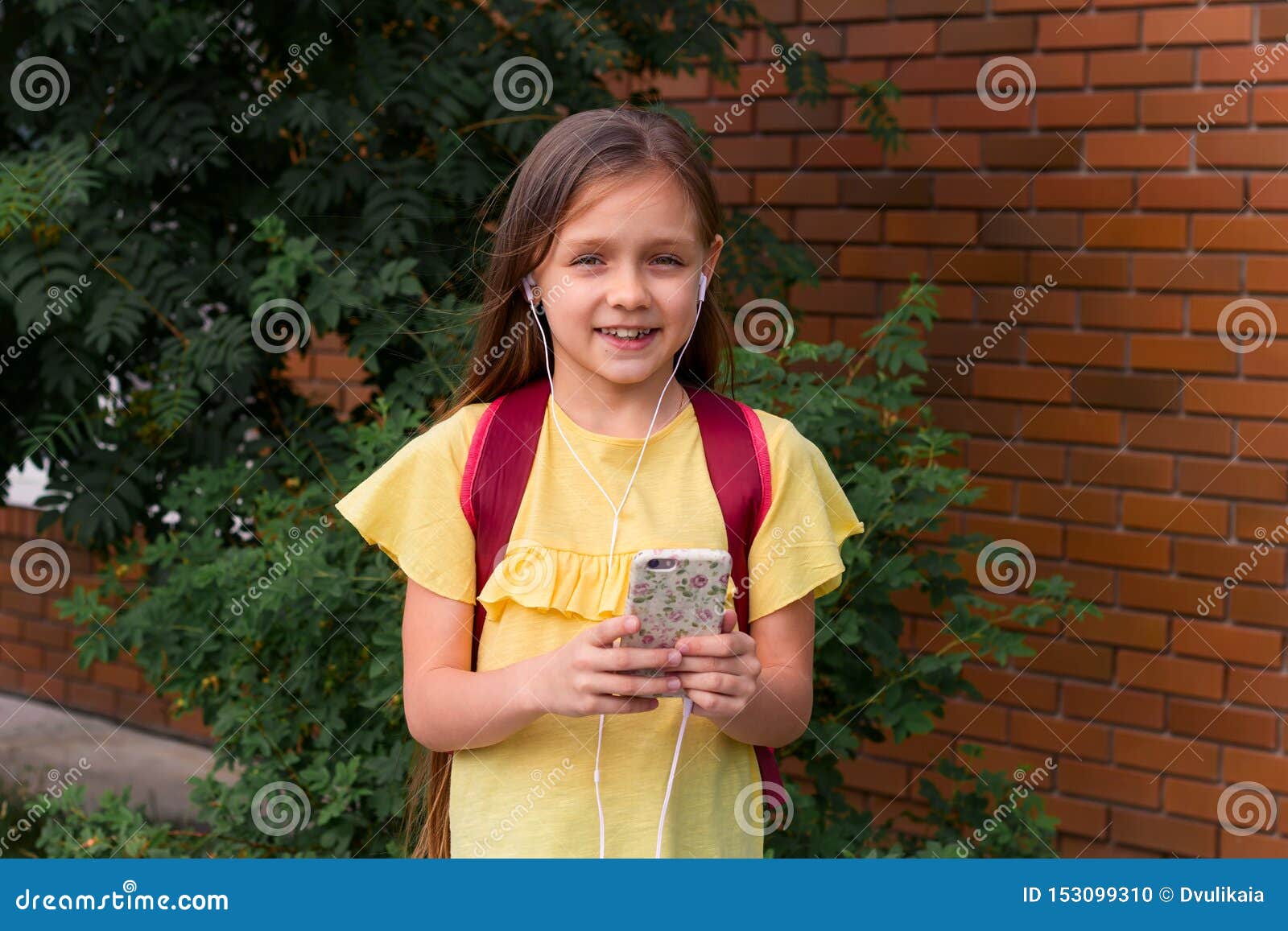 Beautiful Little Girl with a Backpack Using a Mobile Phone Stock Photo ...