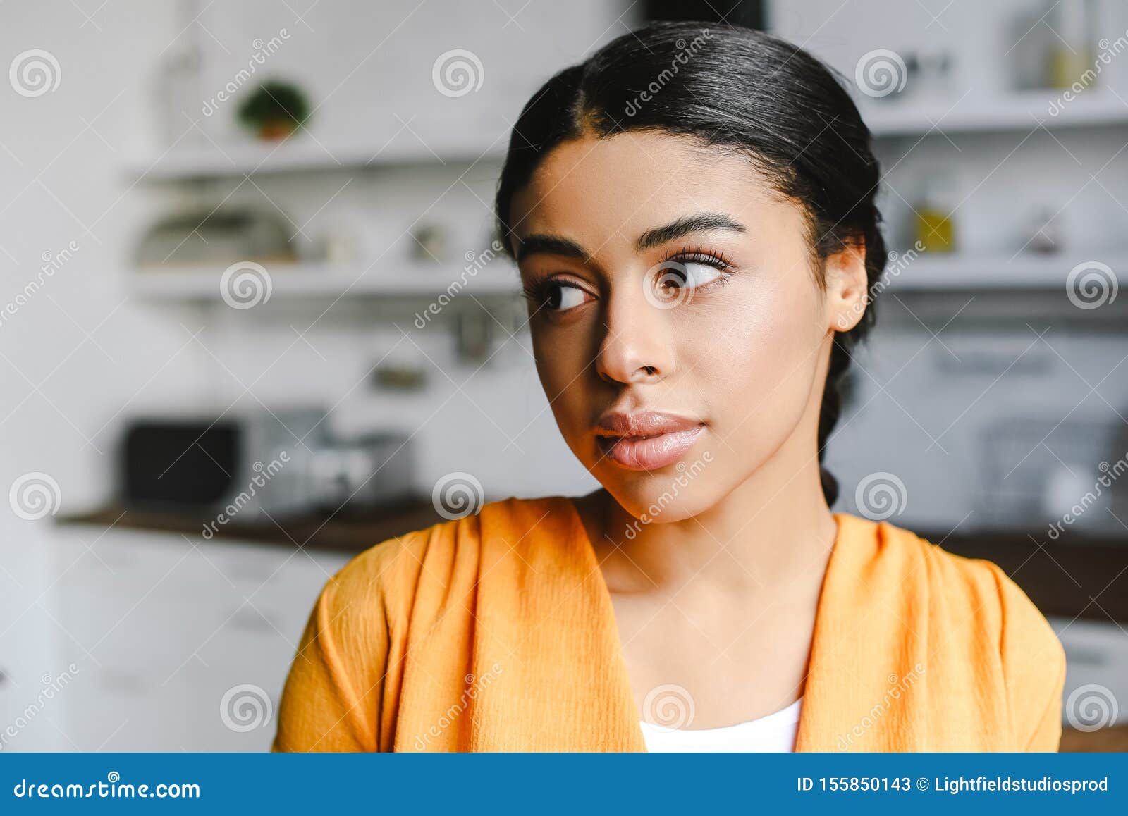 Portrait Of Beautiful Mixed Race Girl In Orange Shirt Looking Away
