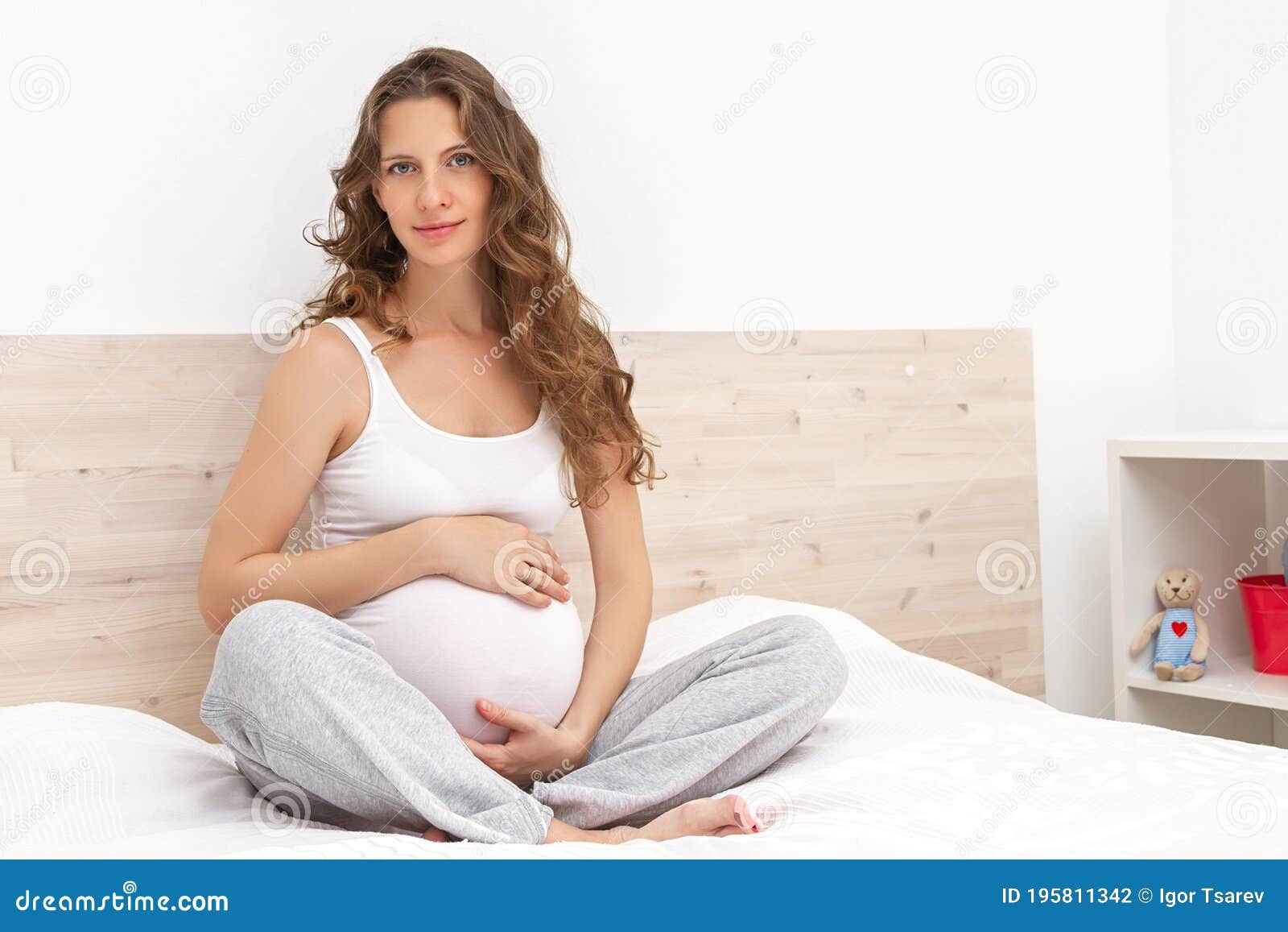 Portrait Of A Beautiful Pregnant Long Haired Woman Sitting On The Sofa