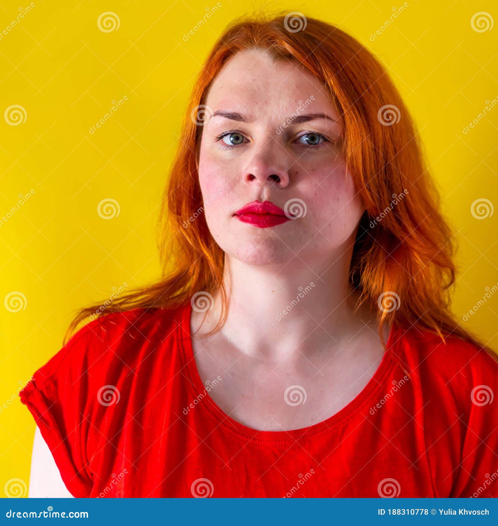 Portrait Of A Beautiful Redhead Girl With Red Lipstick On Yellow
