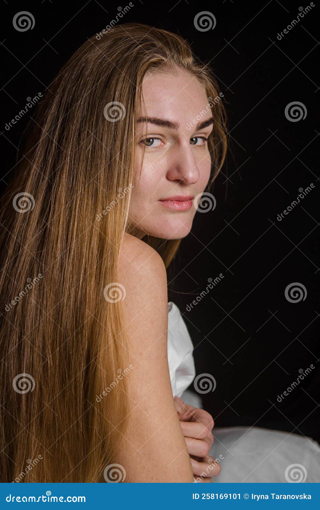 Portrait Of Beautiful Slender Young Woman With Blonde Hair In A White