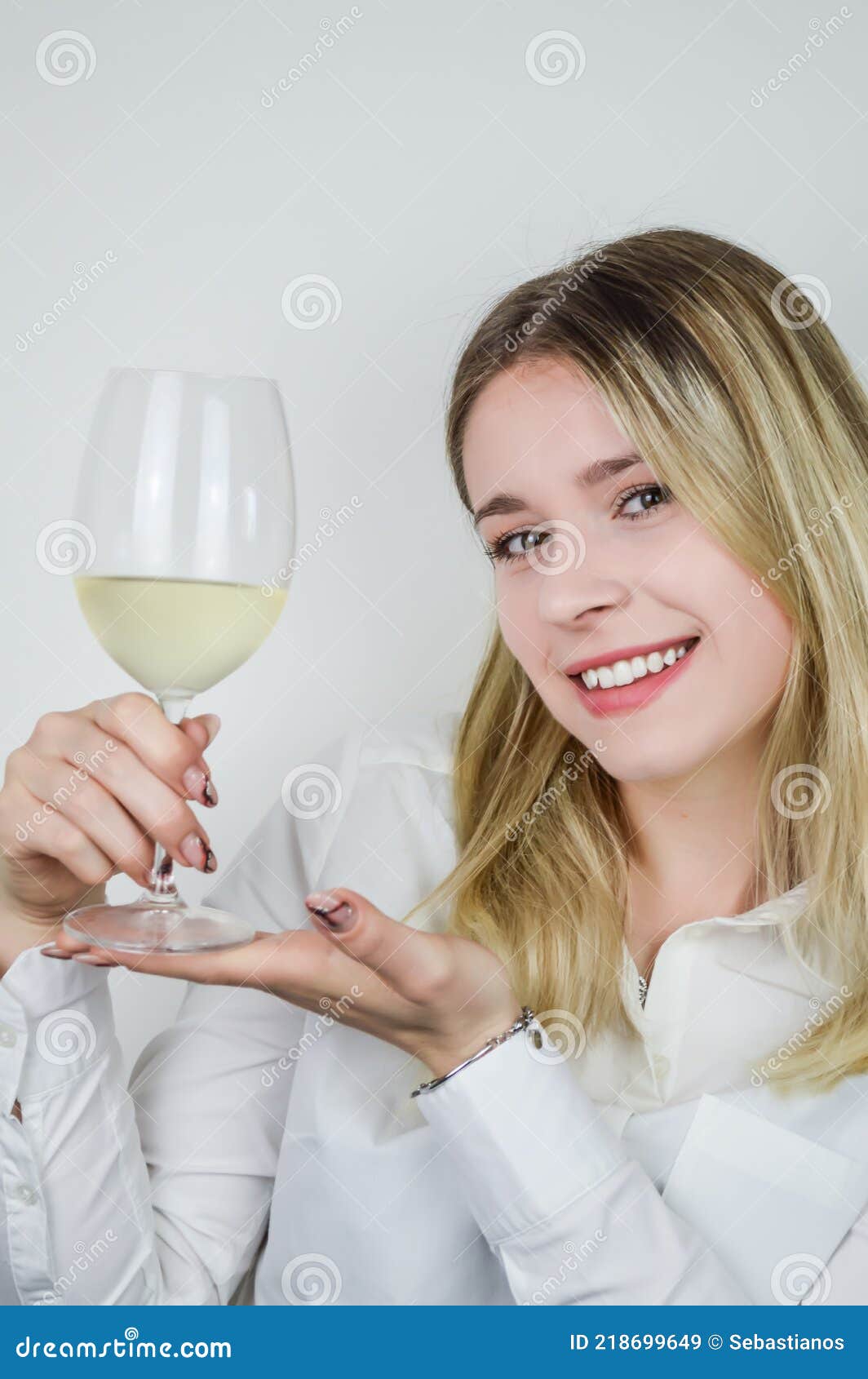 Portrait Of A Beautiful Smiling Young Blonde Woman Holding A Glass Of