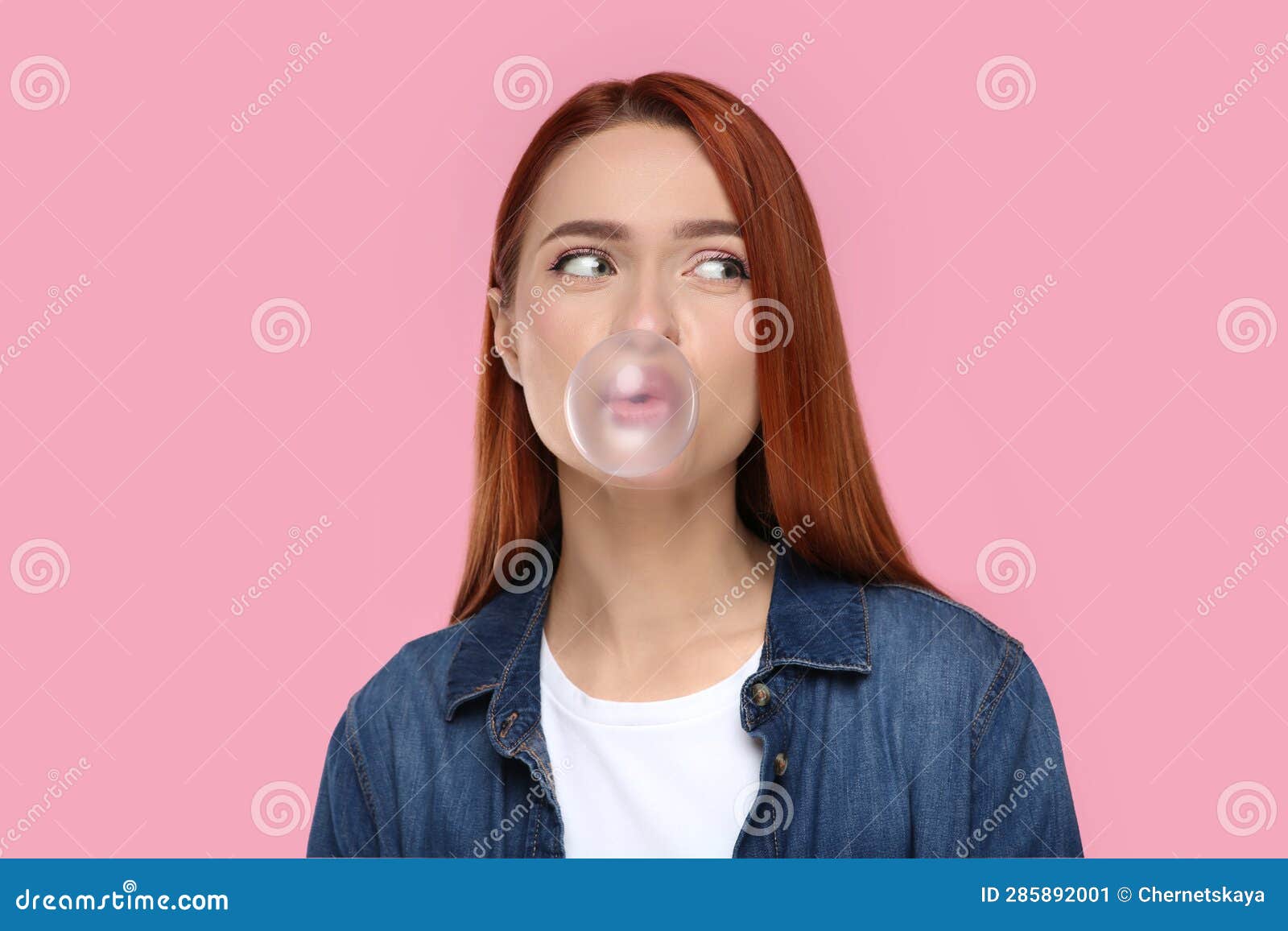 Portrait Of Beautiful Woman Blowing Bubble Gum On Pink Background Stock