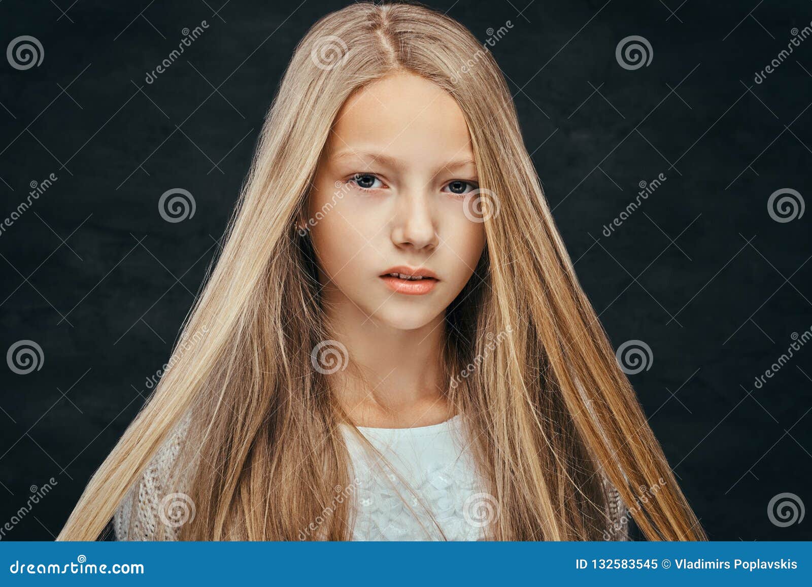 Portrait Of A Beautiful Young Girl With Blonde Hair Looking At A Camera