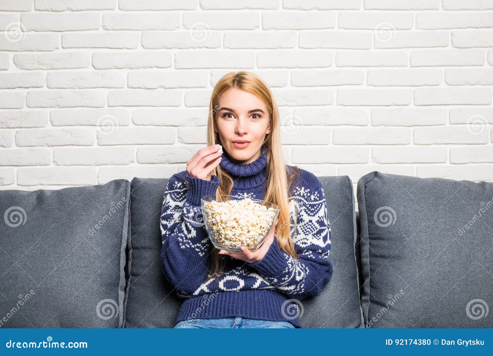 Portrait Of Beautiful Young Woman Eating Popcorn While Watching Movie