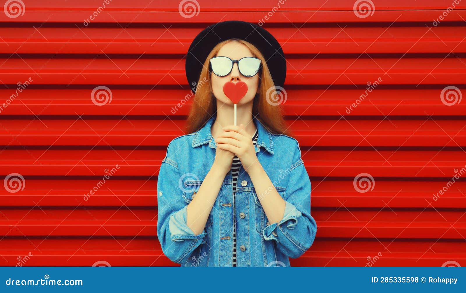 Portrait Of Beautiful Young Woman With Lollipop Blowing Her Lips With