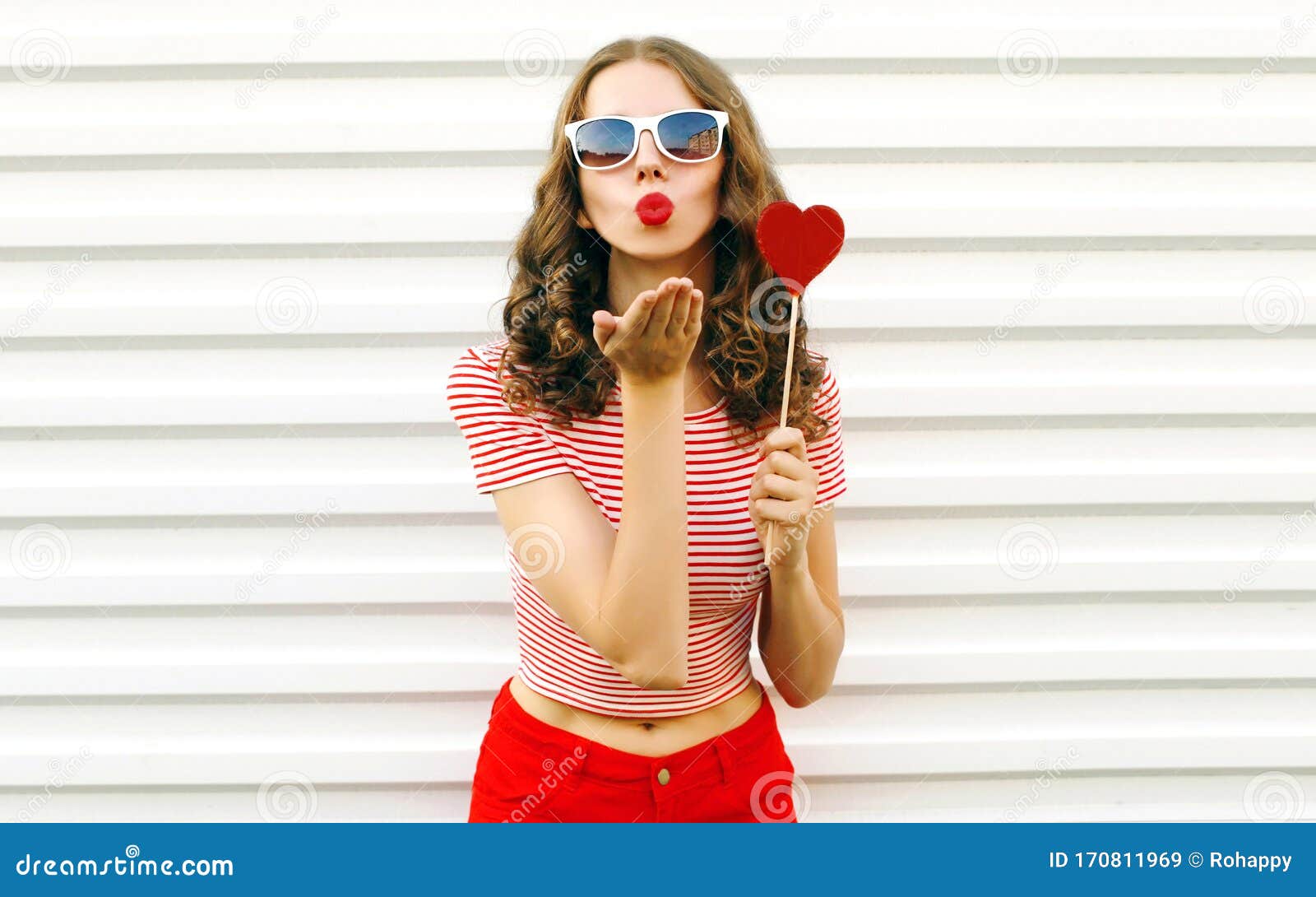 Portrait Beautiful Young Woman With Red Heart Shaped Sunglasses Blowing