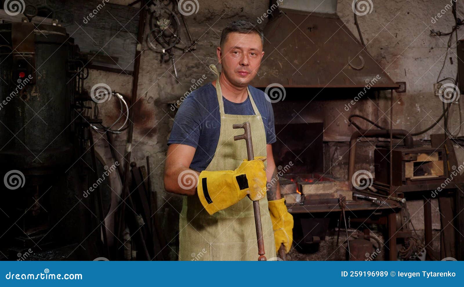 Portrait of a Blacksmith in Uniform with Tools in an Old Forge. Stock ...