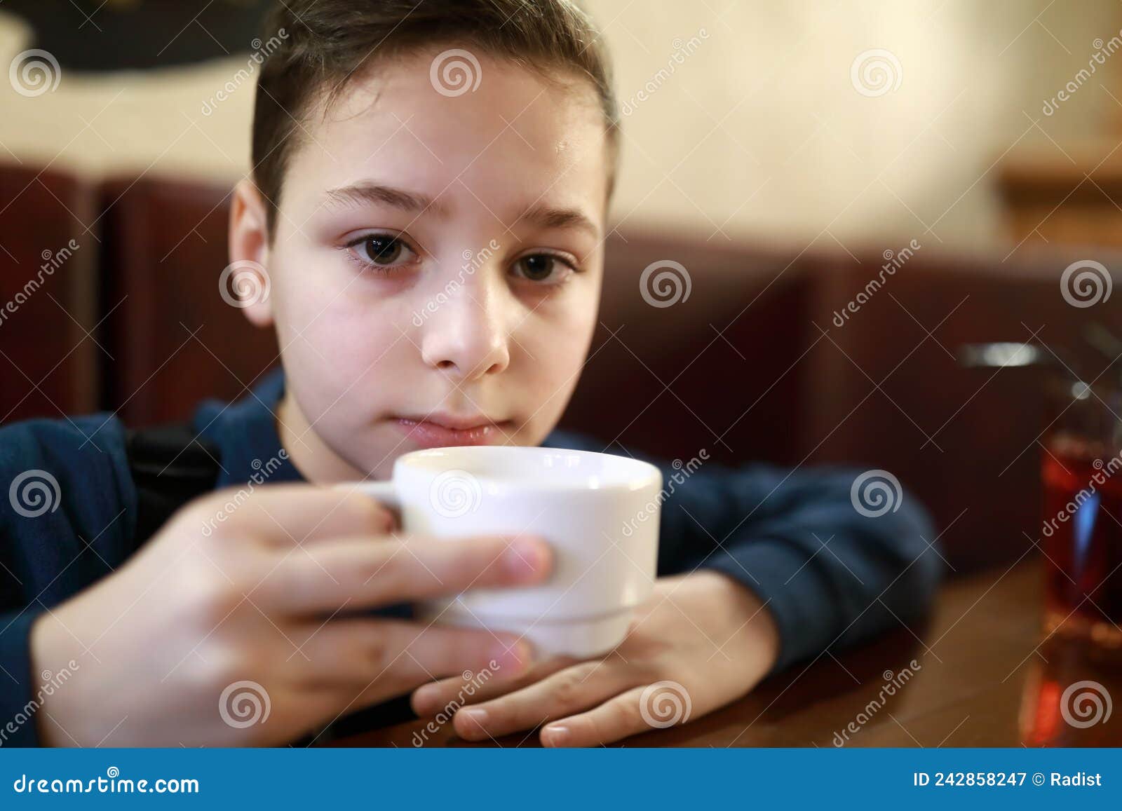 Boy drinking tea in cafe stock image. Image of heat - 242858247
