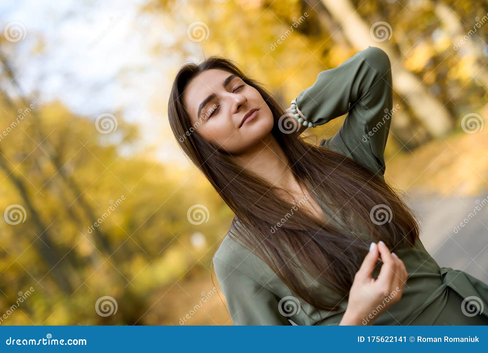 Portrait Of Brunette Woman In Green Dress Posing In Autumn Park Stock