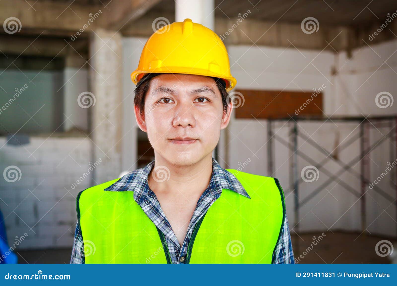 Portrait of a Builder Wearing a Yellow Helmet on a Construction Site ...