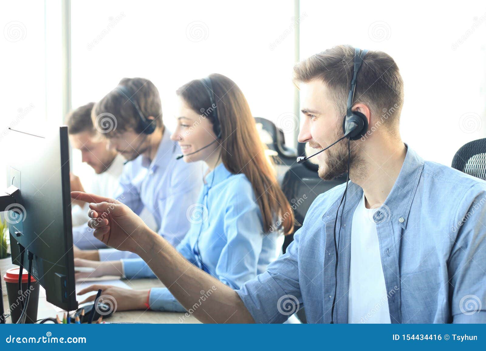 Portrait of Call Center Worker Accompanied by His Team. Smiling ...